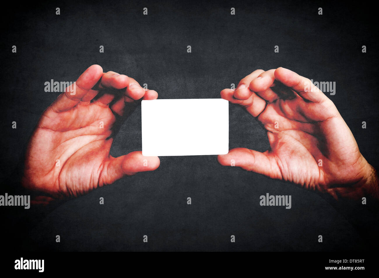 Hands holding blank calling card ion black background Stock Photo - Alamy