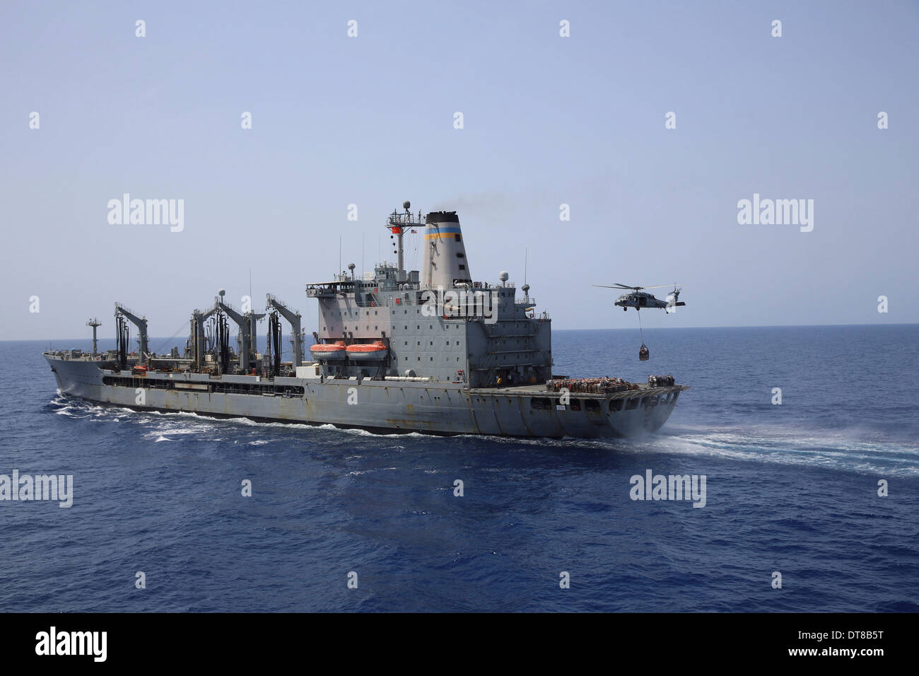 An MH-60S Sea Hawk conducts a vertical replenishment with USNS Laramie ...