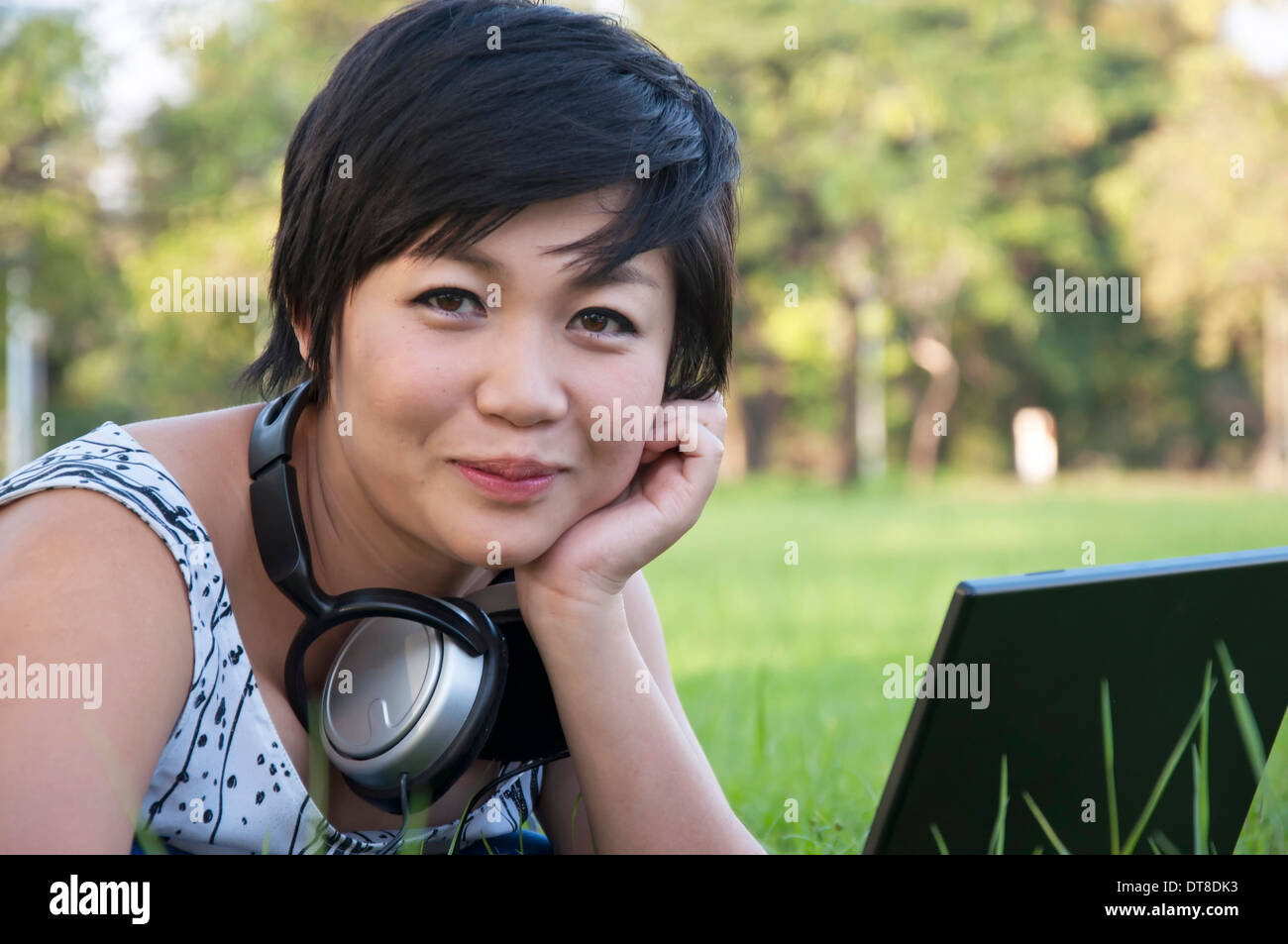 Asian lady using computer in a field Stock Photo - Alamy