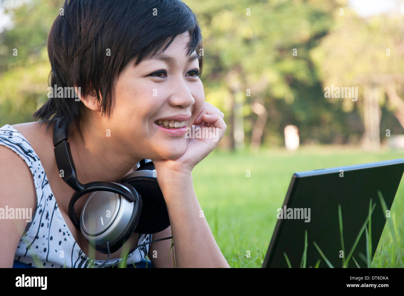 Asian lady using computer in a field Stock Photo - Alamy