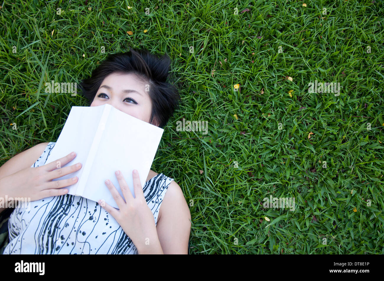 Young woman reading a book in the field Stock Photo - Alamy