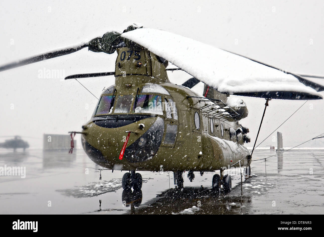 Snow covers a US Army CH-47 Chinook Helicopter during a winter ...
