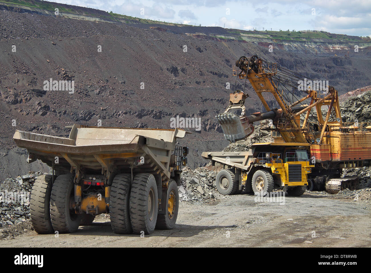 Trucks being loaded with iron ore on the opencast mining site Stock ...