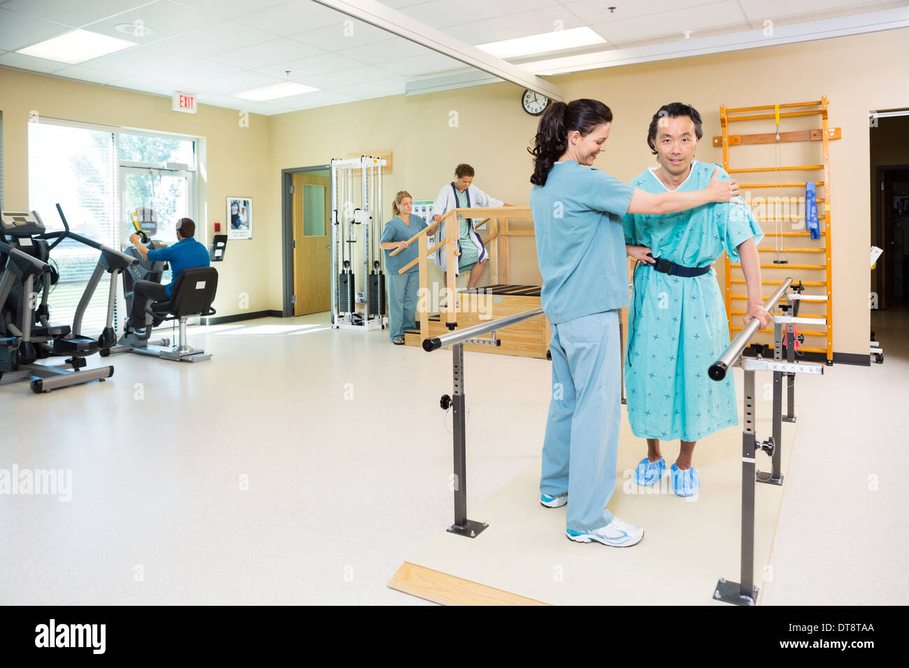 Therapists Assisting Patients In Hospital Gym Stock Photo - Alamy