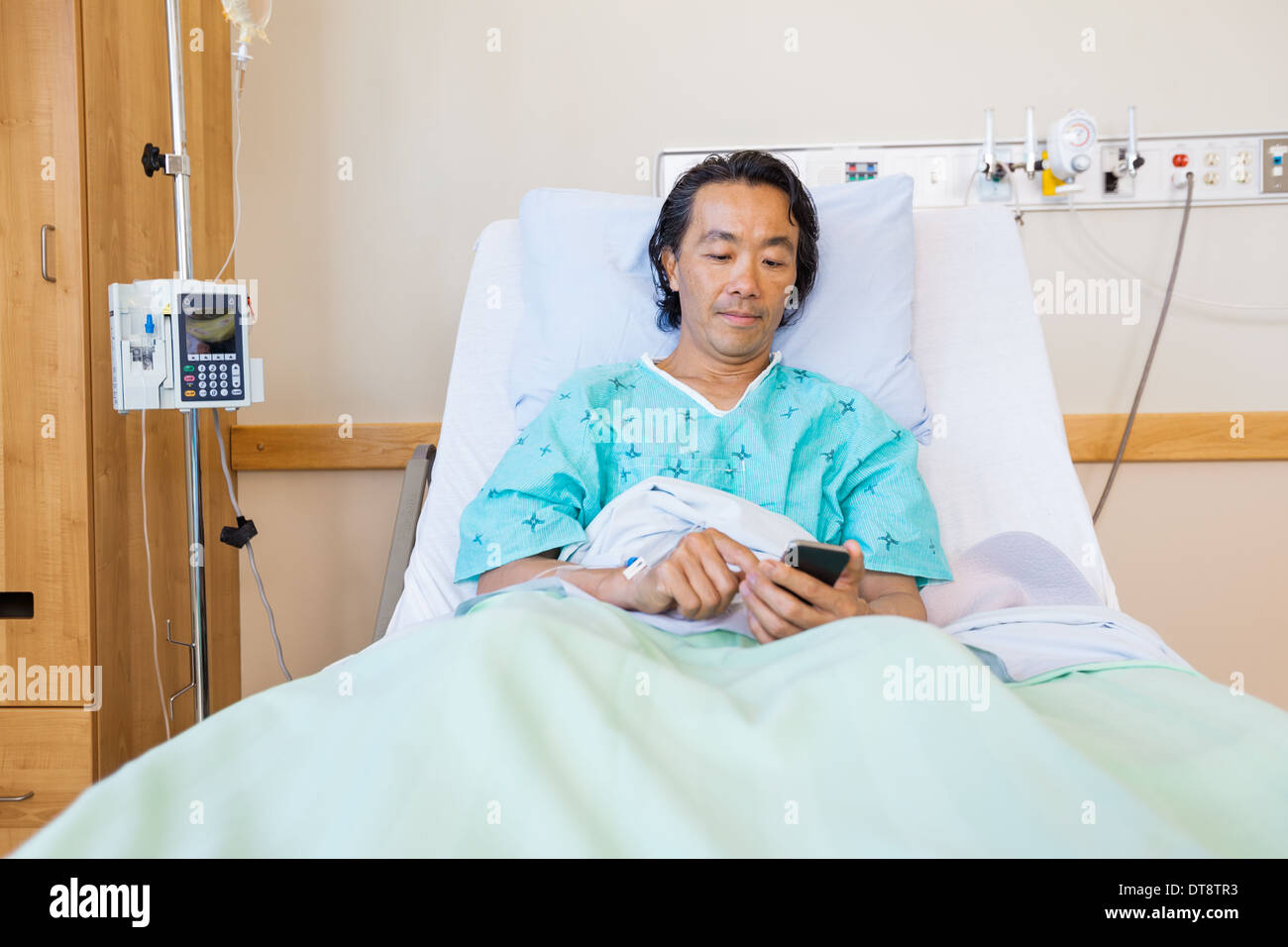 Patient Text Messaging Through Cell Phone On Hospital Bed Stock Photo ...