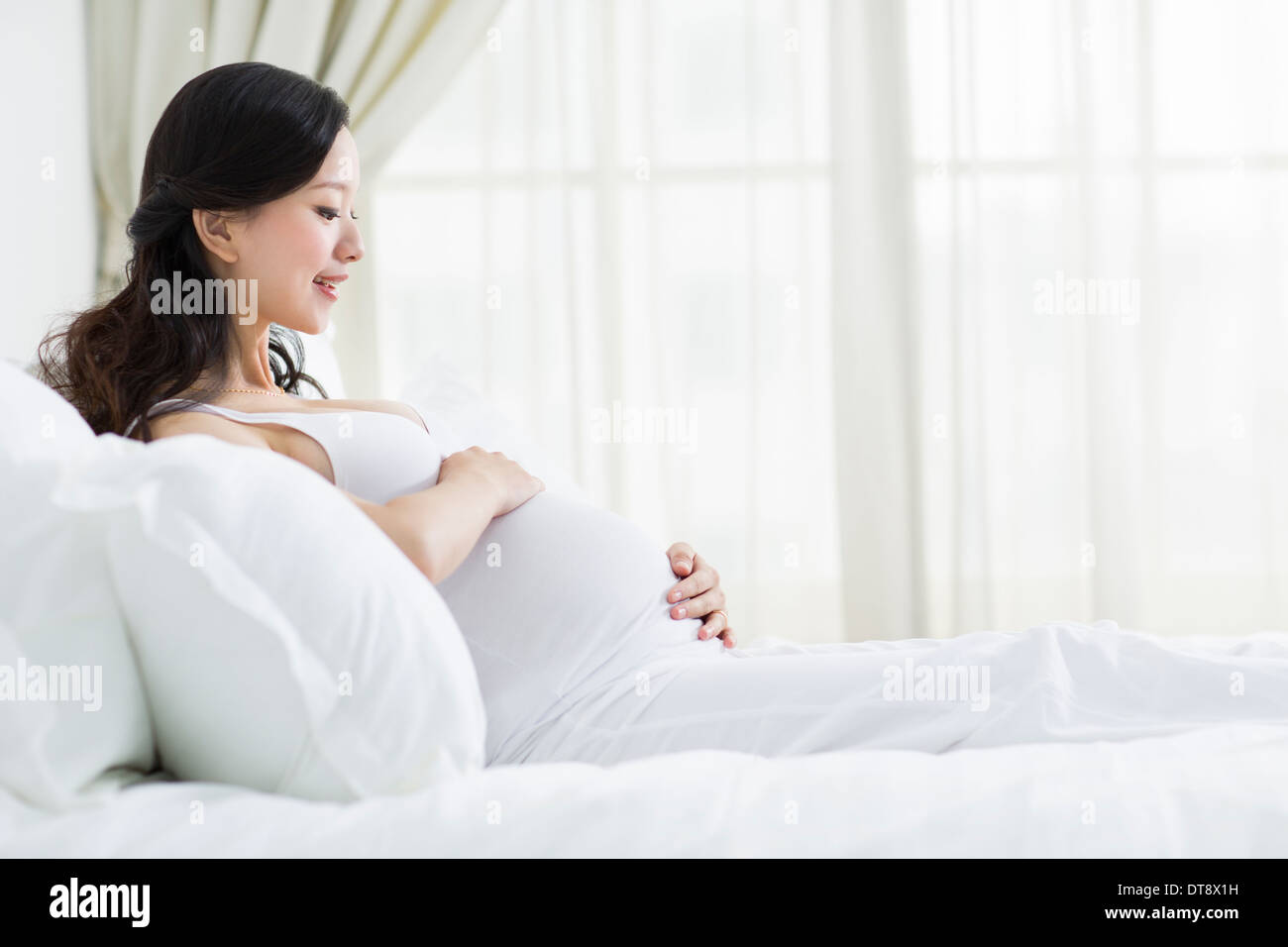 Pregnant woman resting in bed Stock Photo - Alamy