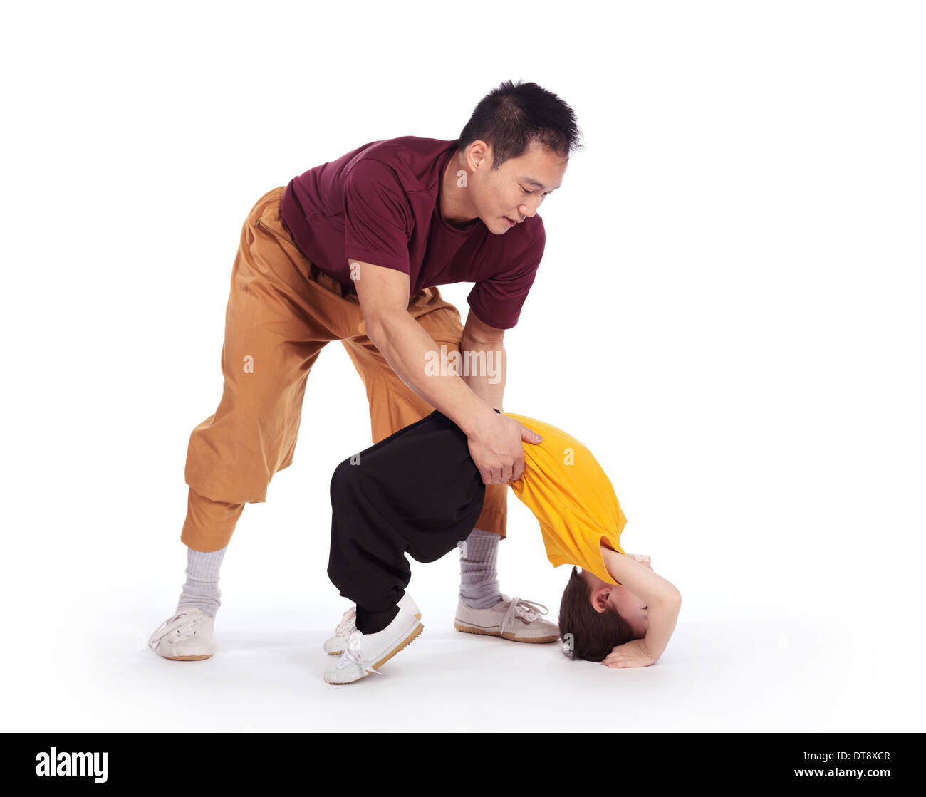 Martial art instructor helping a child to hold a bridge stand isolated ...