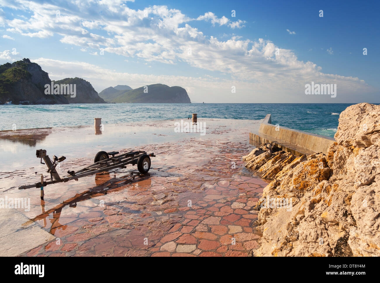 Stone breakwater and old boat trailer, Montenegro Stock Photo - Alamy