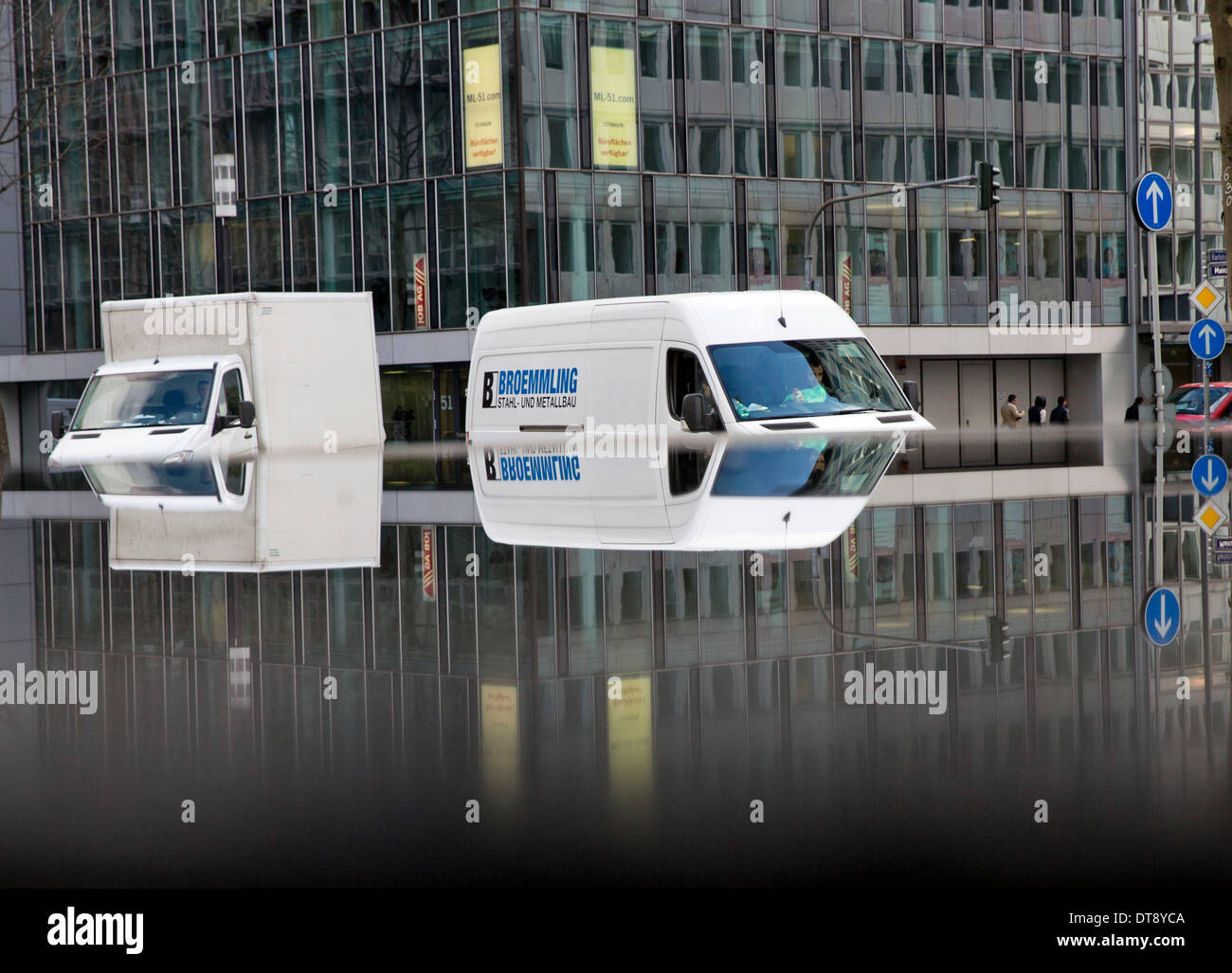 Two delivery vans are reflected in a pool at the base of an artwork in ...