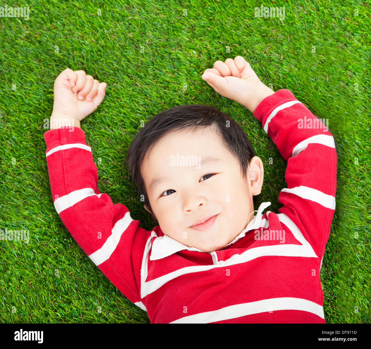 little smiling boy resting and hand up in meadow or grassland Stock ...