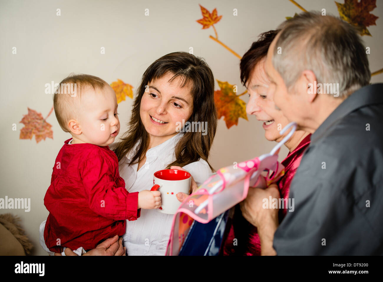 Grandparents with their small grandchild celebrating first birthday at ...