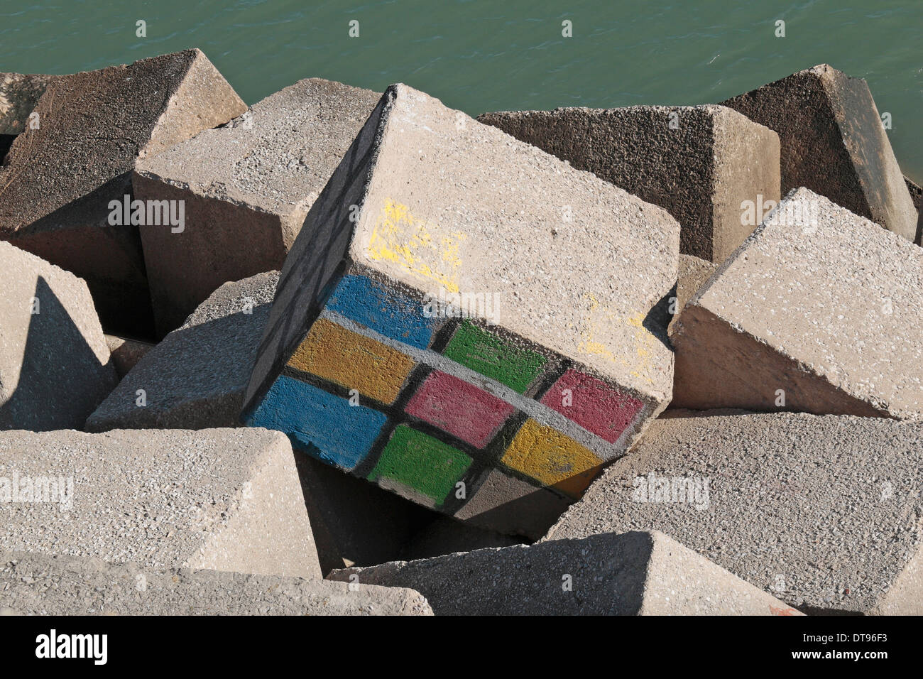 Painted concrete boulder making up the sea wall in Cadiz, Andalusia ...