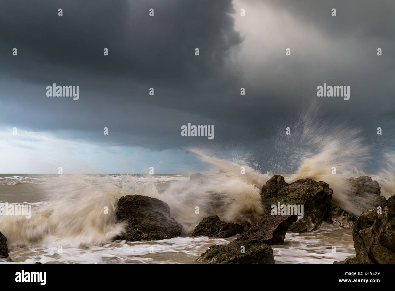 Waves crashing around rocks during a storm Stock Photo - Alamy