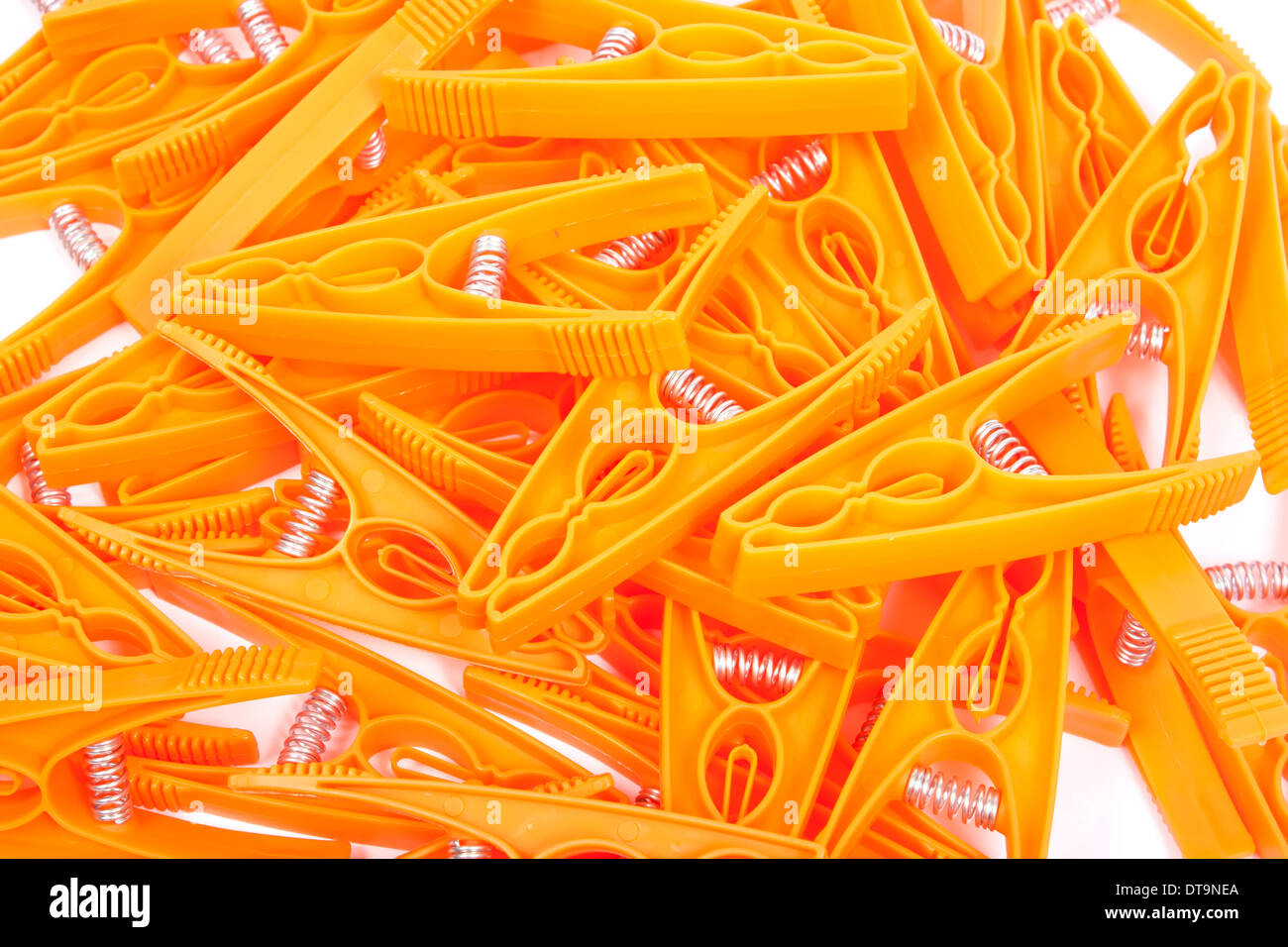 Orange clothes pegs over white background Stock Photo - Alamy