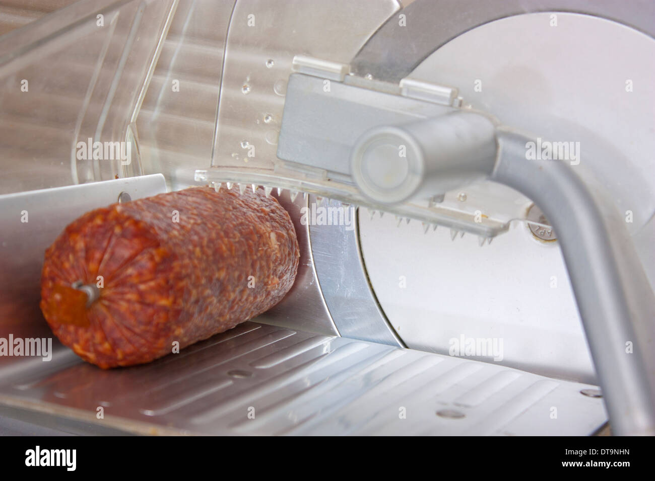 A salami during cutting process Stock Photo - Alamy