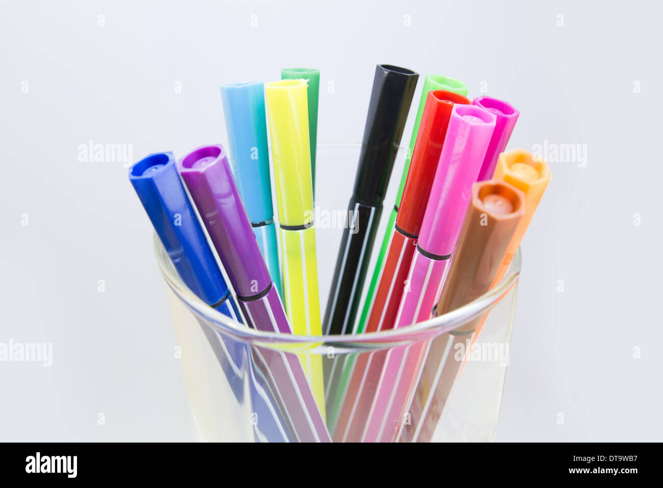 Group of color felt-tipped pens in a white cup, white background ...