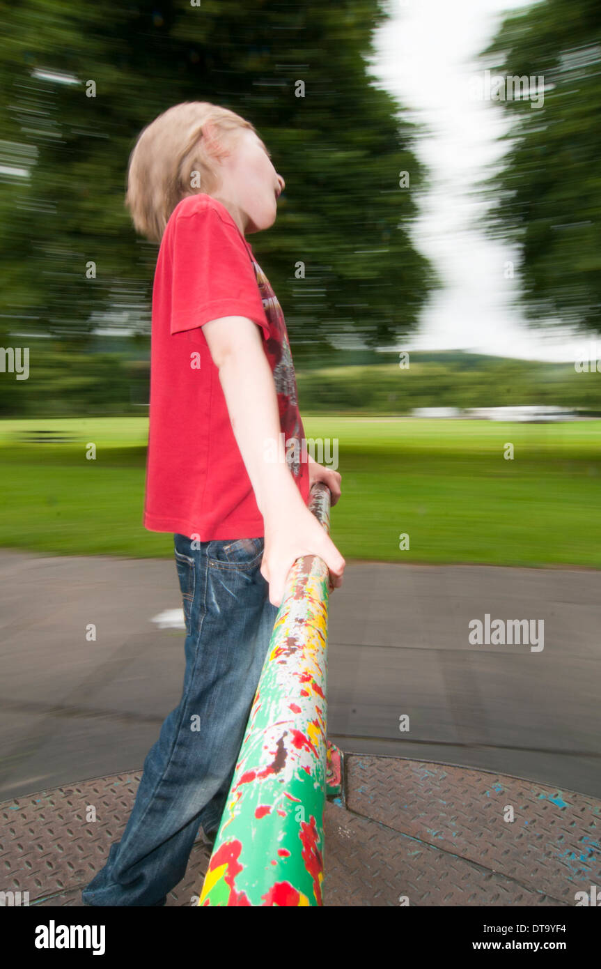 Boy standing on spinning roundabout Stock Photo - Alamy