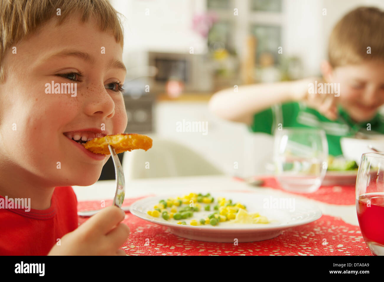 Two children eating fish fingers hi-res stock photography and images ...