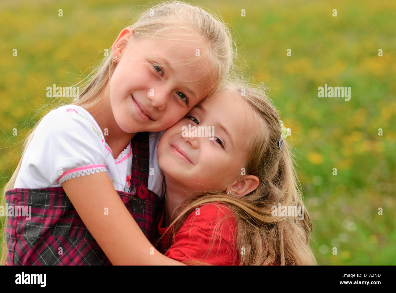 Two sisters hug one another outdoors, happy family Stock Photo - Alamy