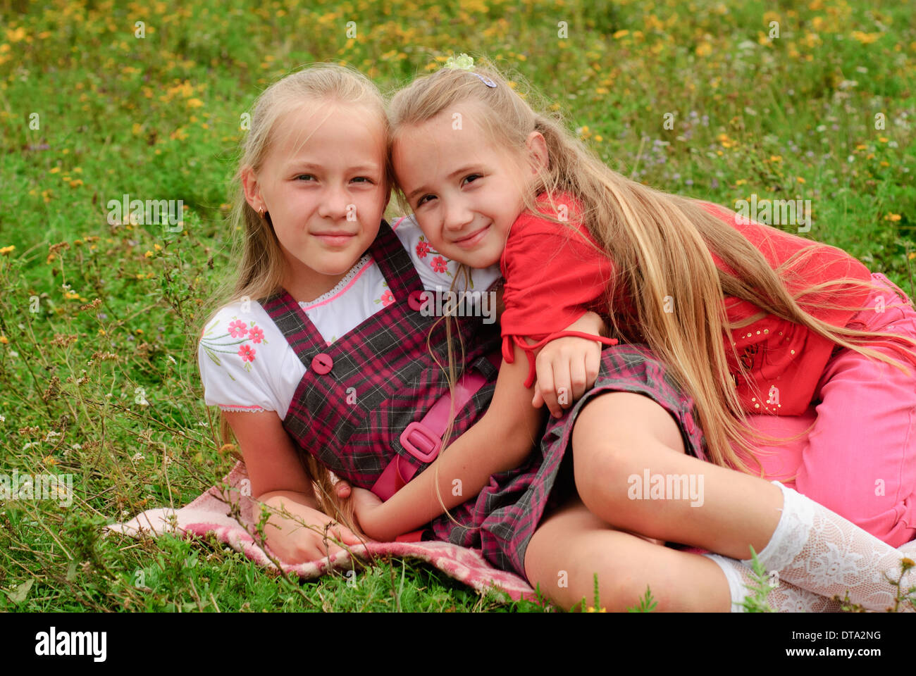 Two sisters hug one another outdoors, happy family Stock Photo - Alamy