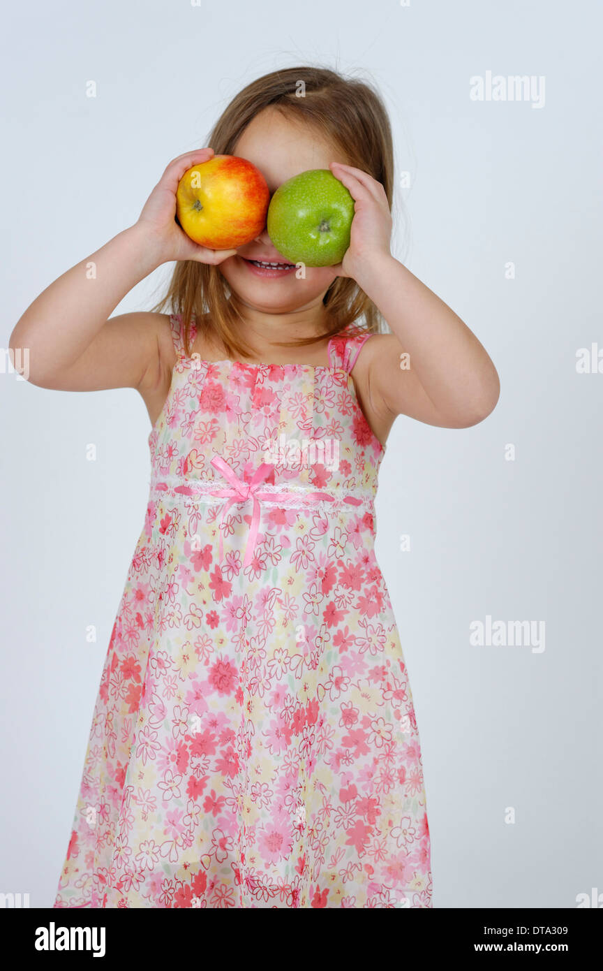 Girl with a red and a green apple in front of her face Stock Photo - Alamy