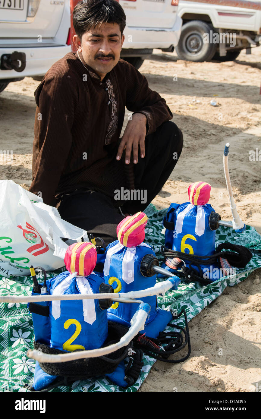 Man selling small robot jockeys at camel racing club at Al Marmoum ...