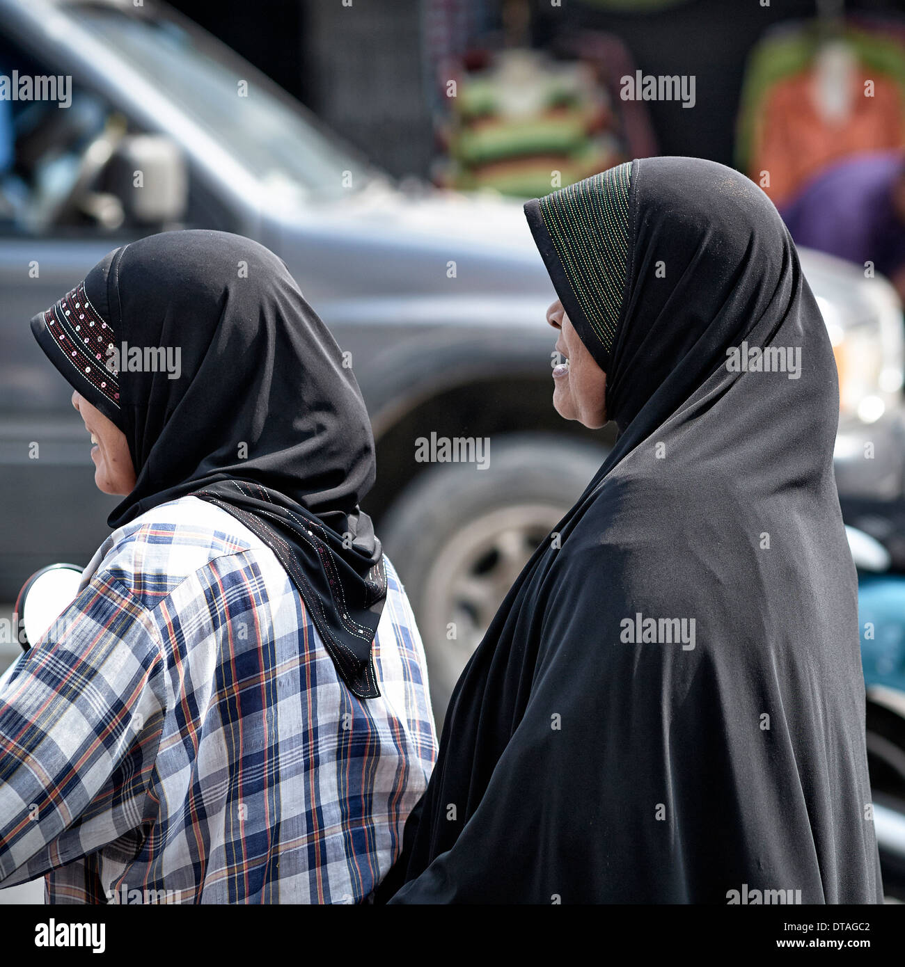 Muslim woman in traditional hijab riding motorcycle. Thailand S. E ...