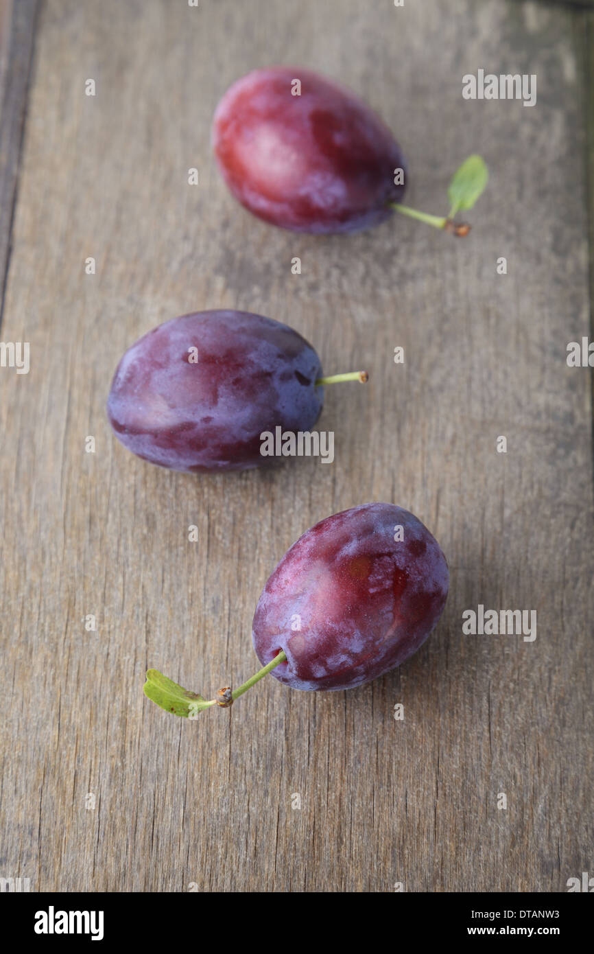 ripe plums on old wood table, rustic style Stock Photo - Alamy