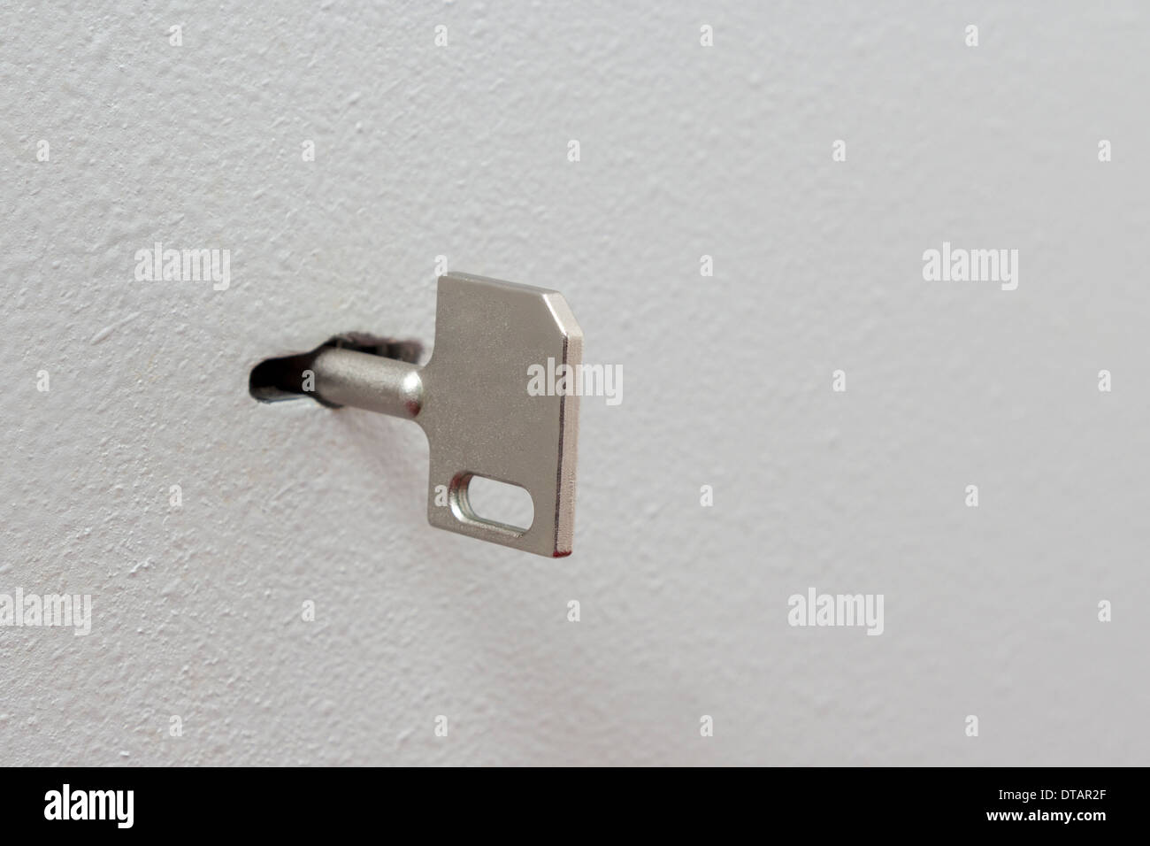 Silver Key in the keyhole of a gray safe Stock Photo - Alamy