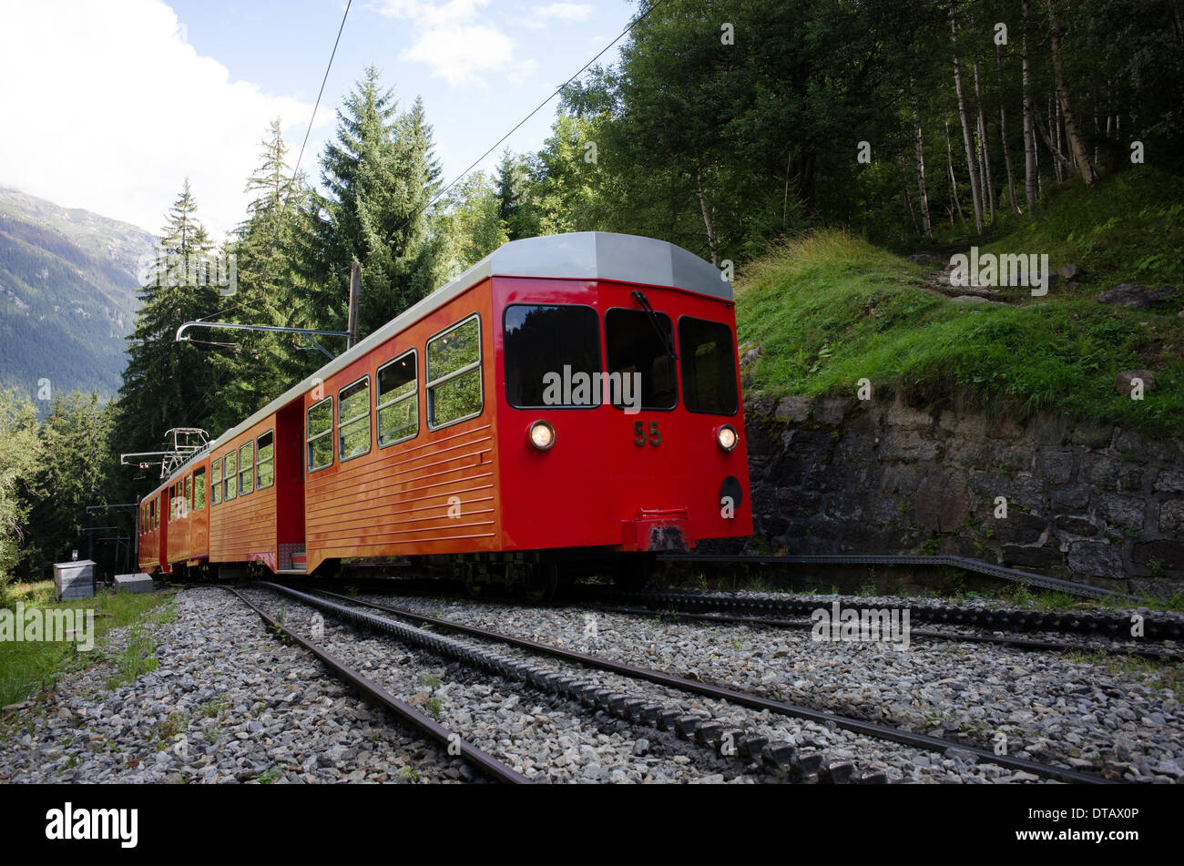 A red and white train of the Montenvers rack railway climbs through the ...