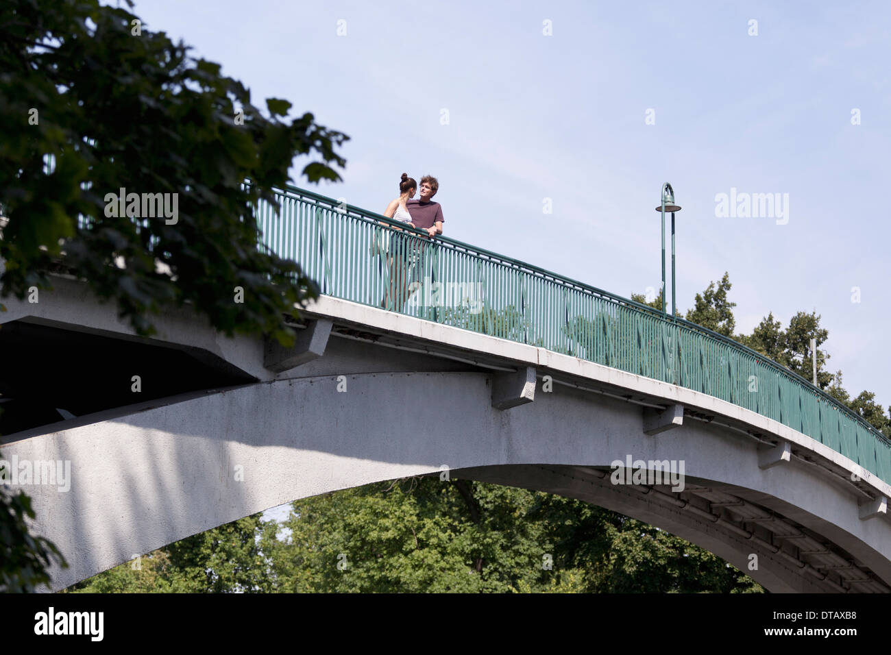 Young couple standing on bridge Stock Photo - Alamy