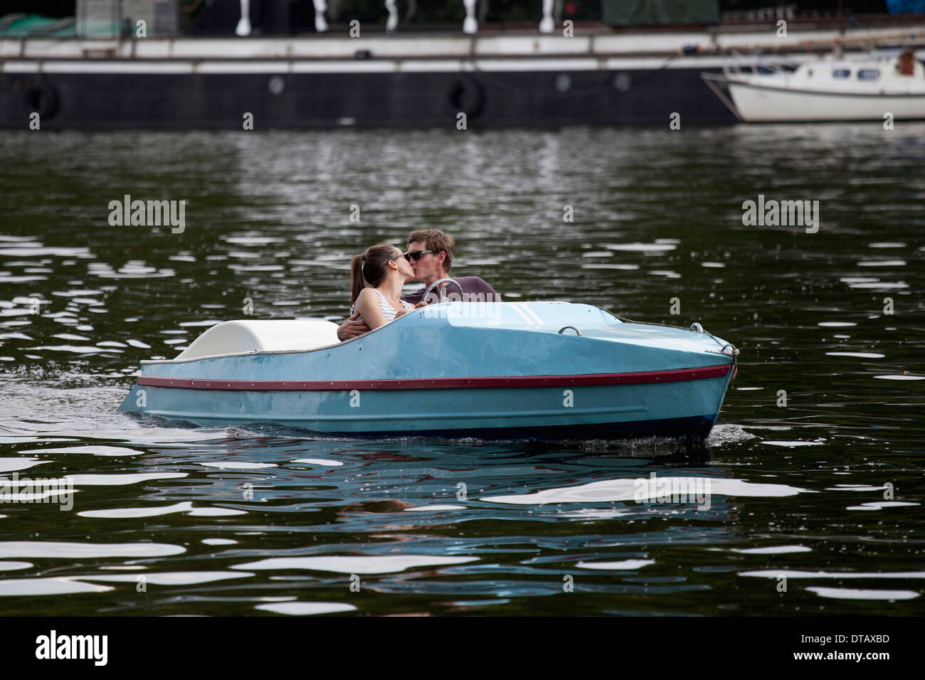 Young couple in paddle boat, kissing Stock Photo - Alamy