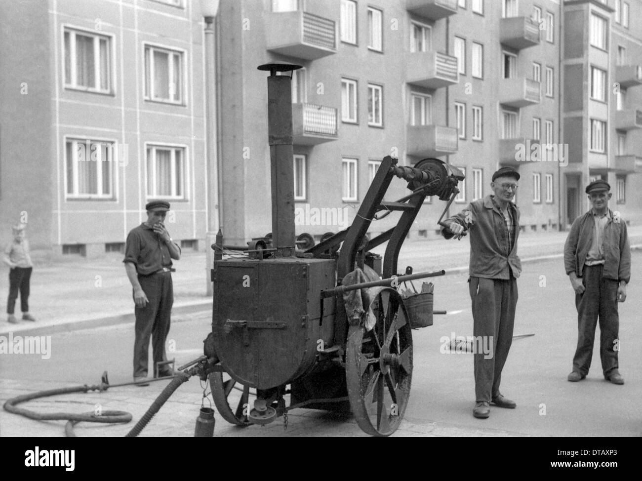 Workers with a tar boiler during road construction, Berlin, GDR Stock ...