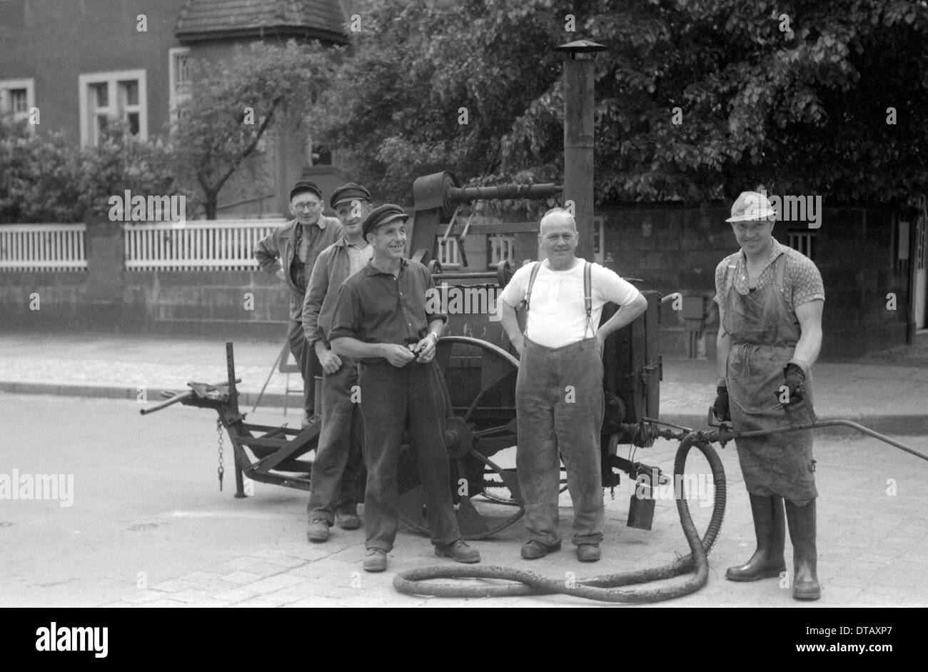 Workers with a tar boiler during road construction, Berlin, GDR Stock ...