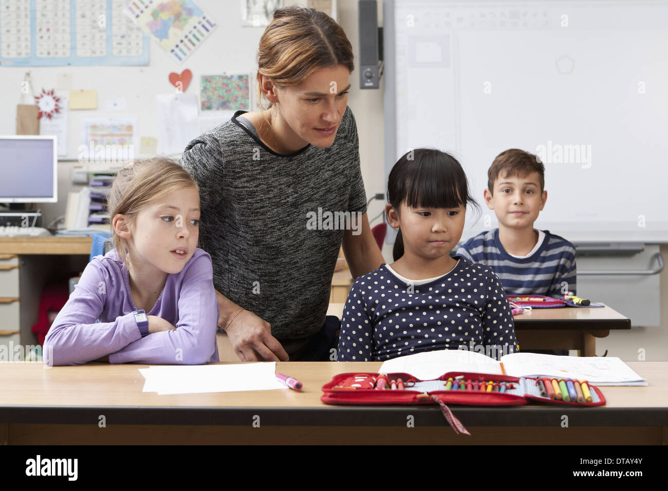 Teacher teaching to students in classroom Stock Photo - Alamy
