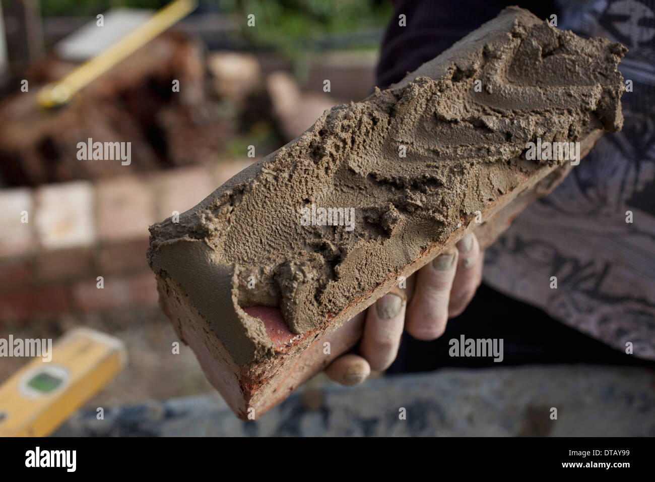 A senior man holding brick, close-up Stock Photo - Alamy