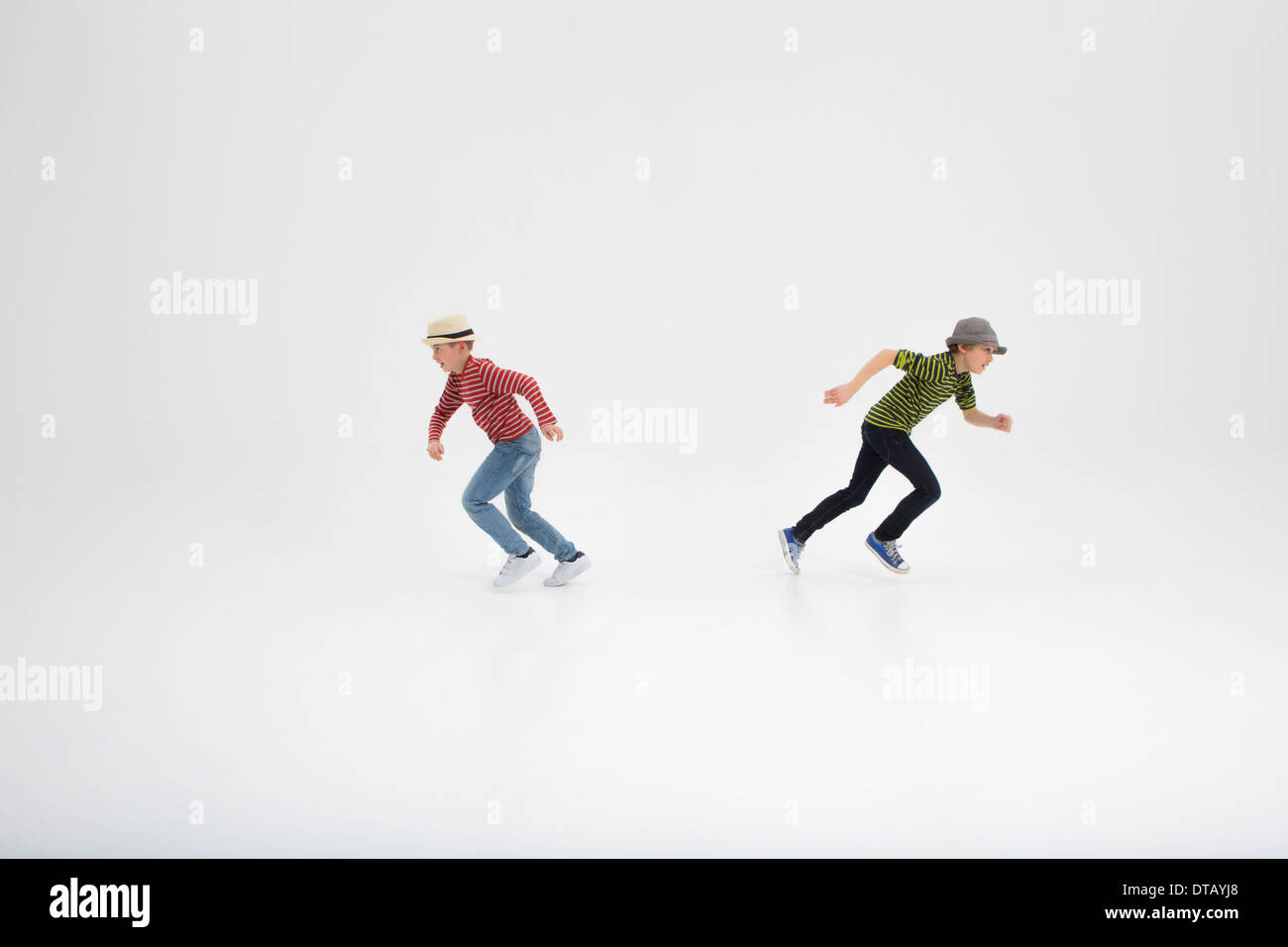 Two boys running opposite direction against white background Stock ...