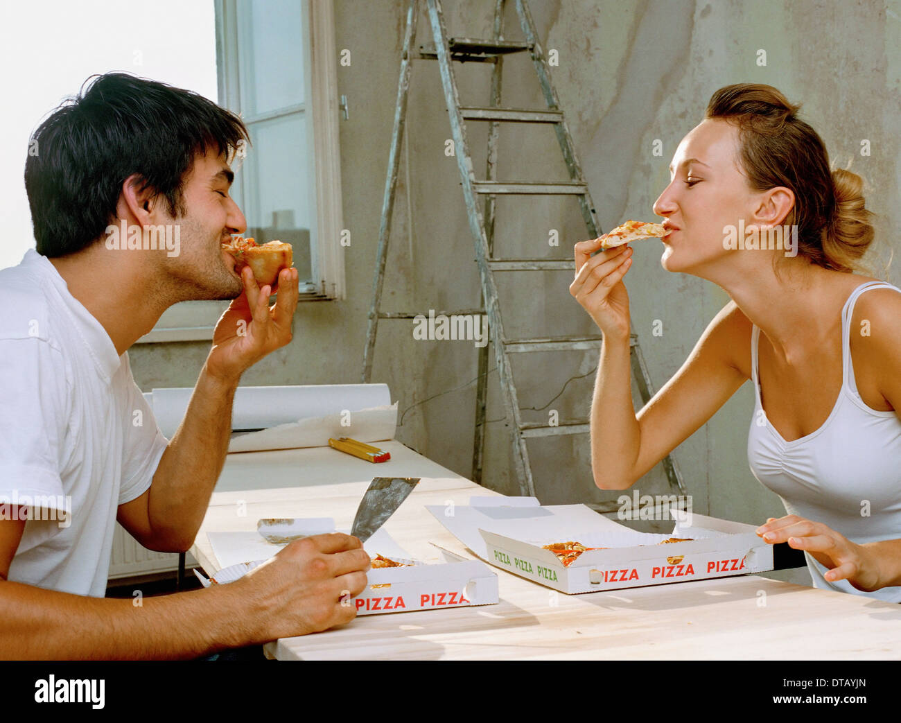 Couple eating pizza at table hi-res stock photography and images - Alamy