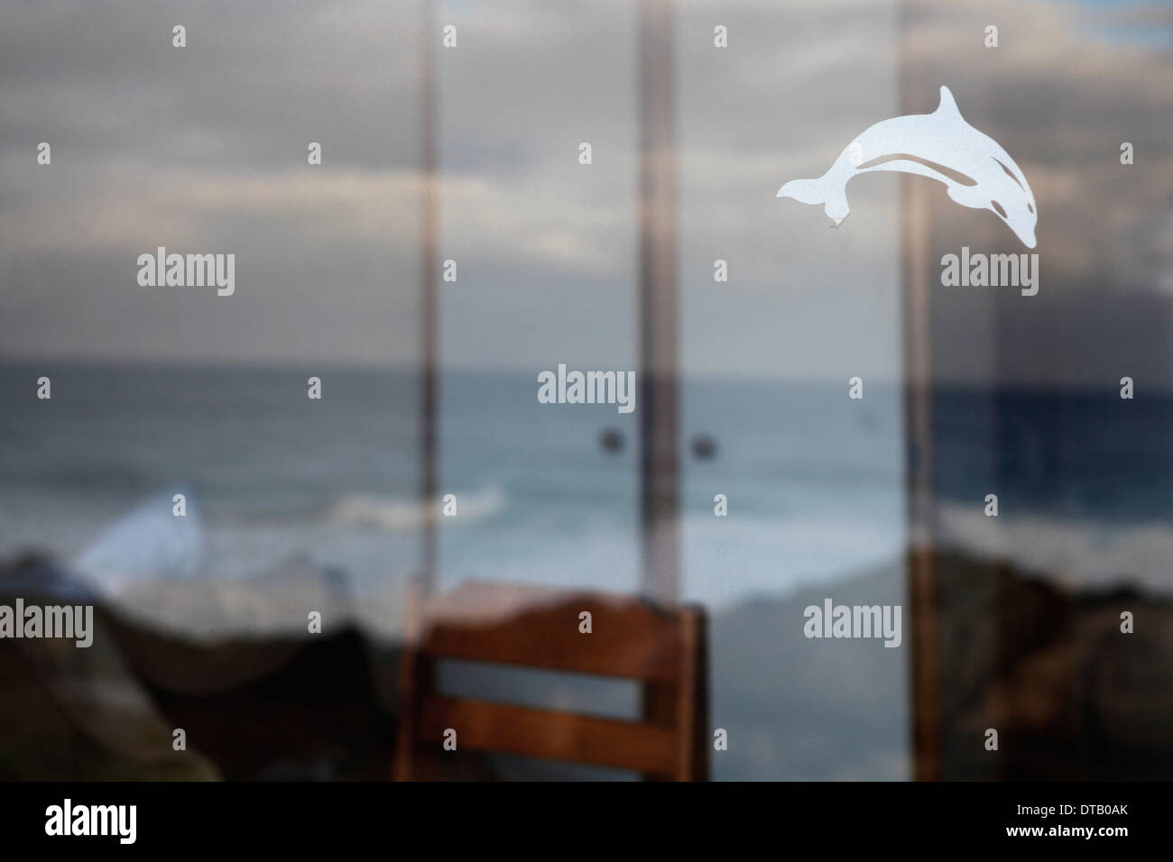 View of rough sea through window with dolphin decal on it Stock Photo ...