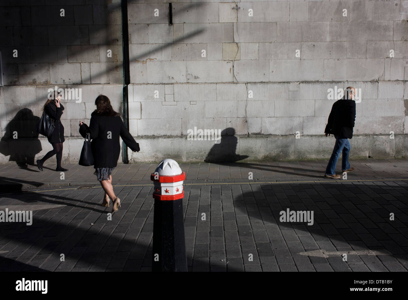City of London bollard and passers-by shadows on church wall Stock ...
