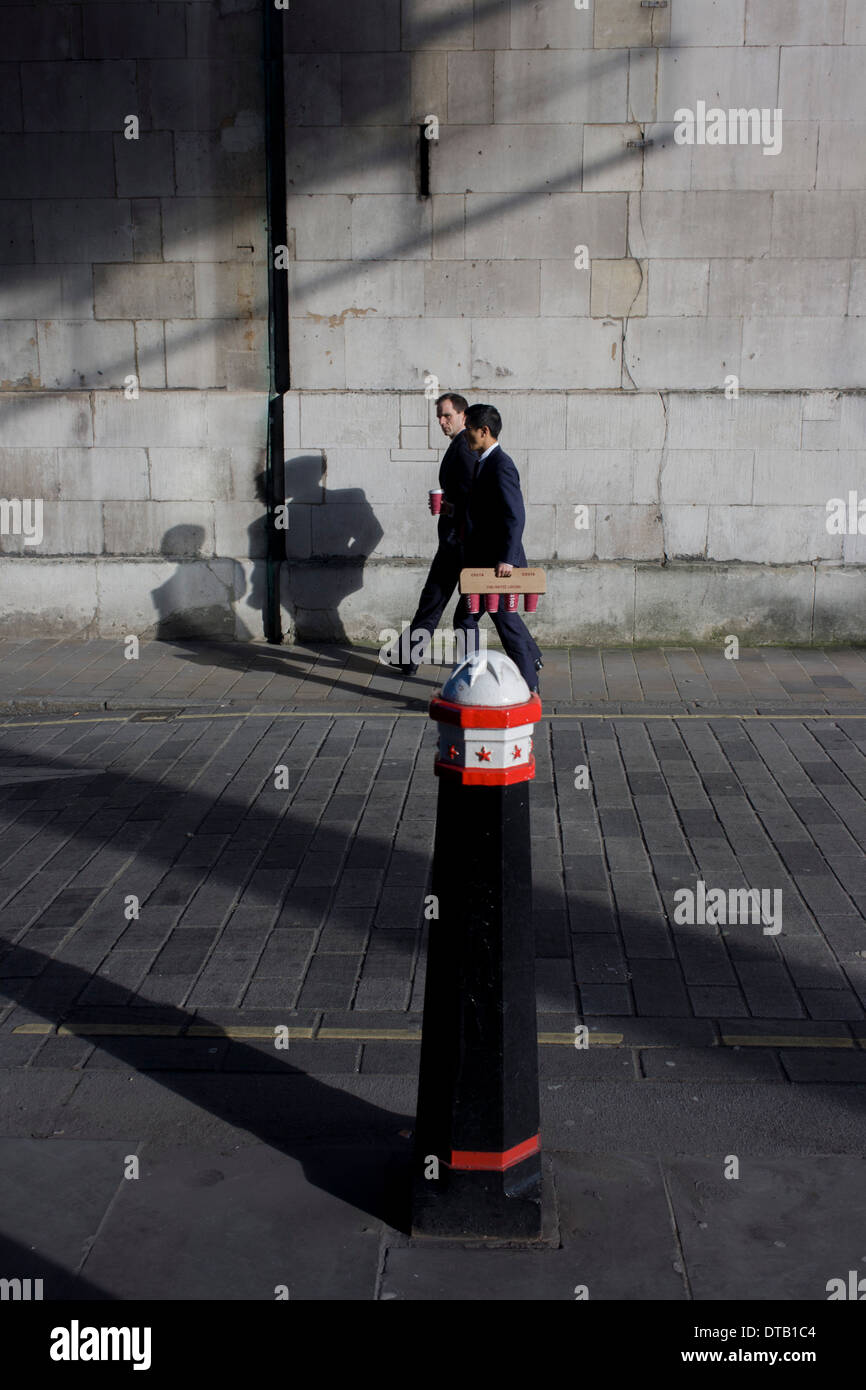 City of London bollard and businessmens' shadows on church wall Stock ...