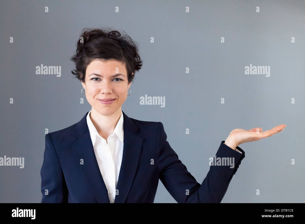 A smiling mid adult woman with her palm out in anticipation Stock Photo ...
