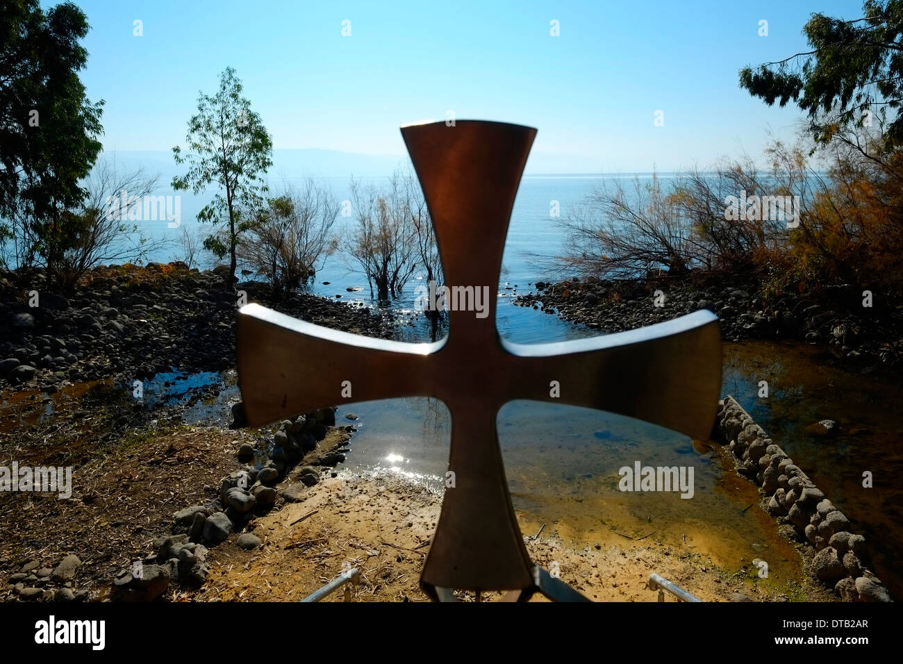 View of the coast of the Sea of Galilee across a cross at complex of ...