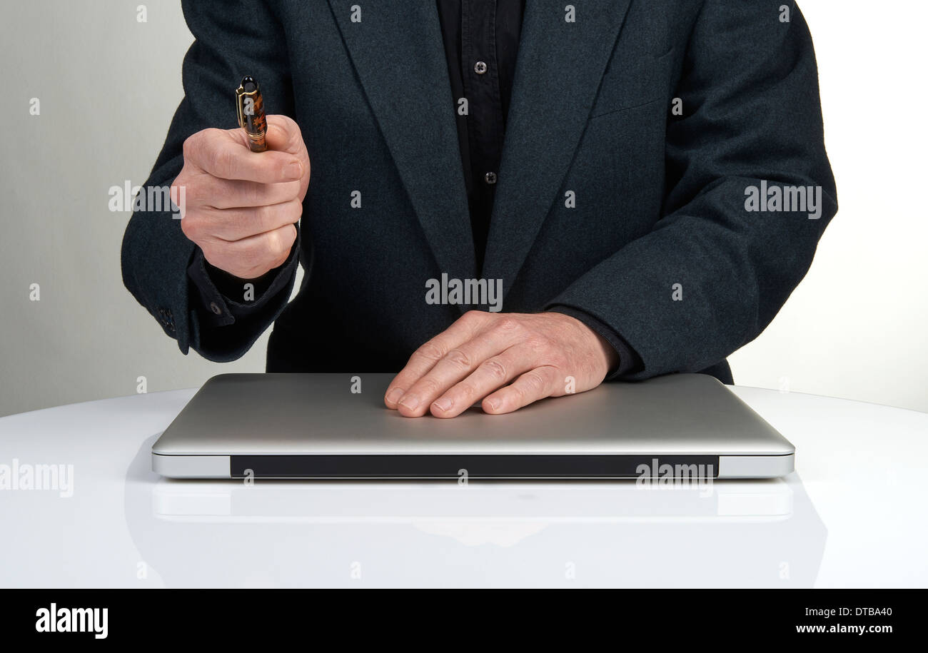Business man with laptop pointing a pen in his office Stock Photo - Alamy