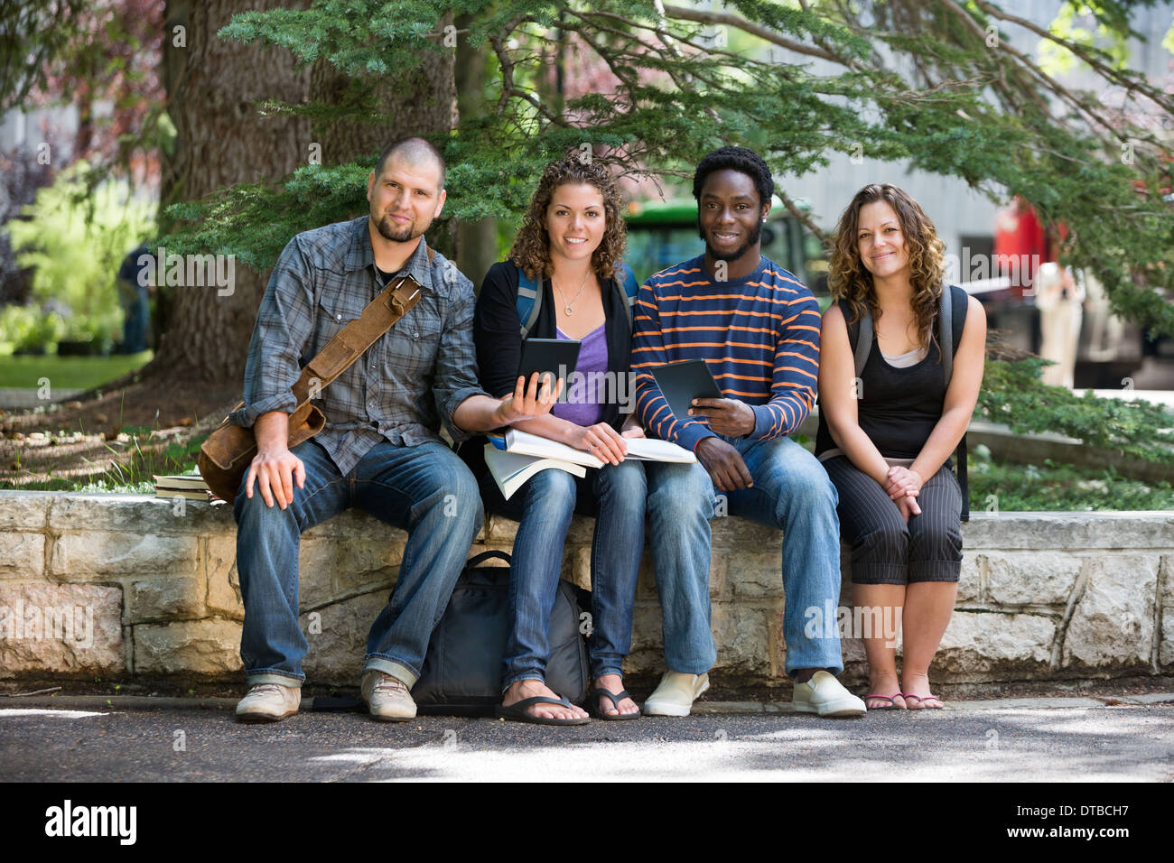 Portrait Of University Students Sitting On Campus Stock Photo - Alamy