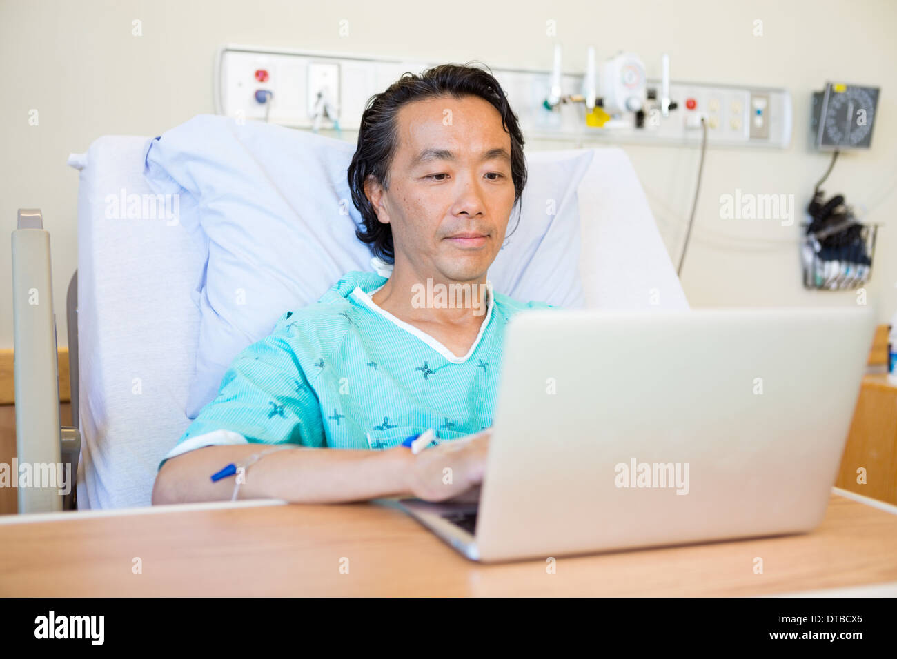 Patient Using Laptop On Hospital Bed Stock Photo - Alamy