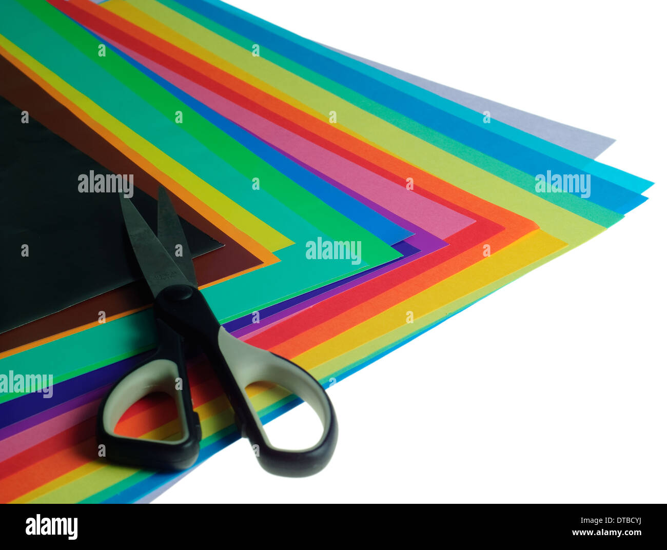 various color paper stack like a rainbow and pair of scissors isolated ...