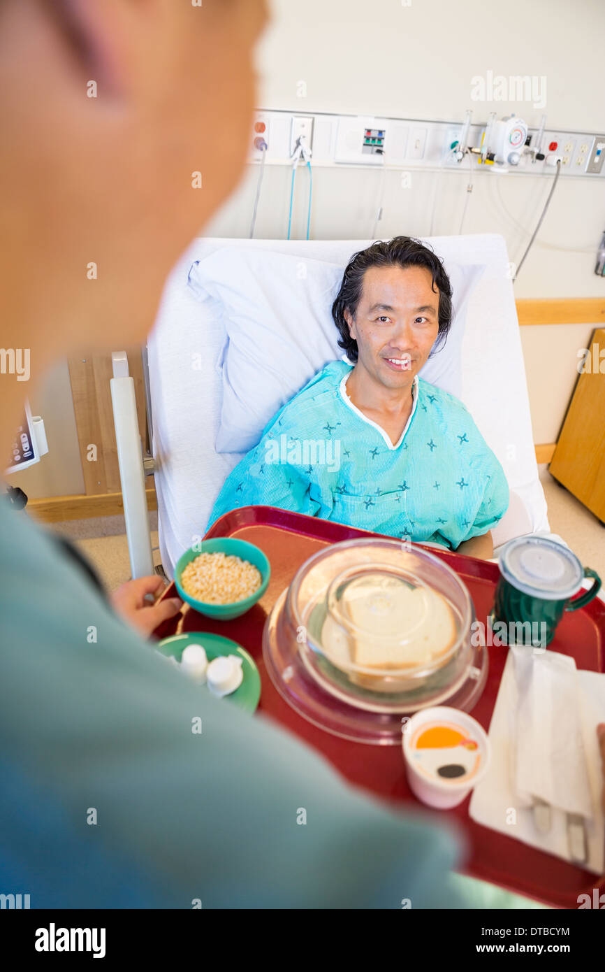 Smiling Patient Looking At Nurse Serving Breakfast Stock Photo - Alamy