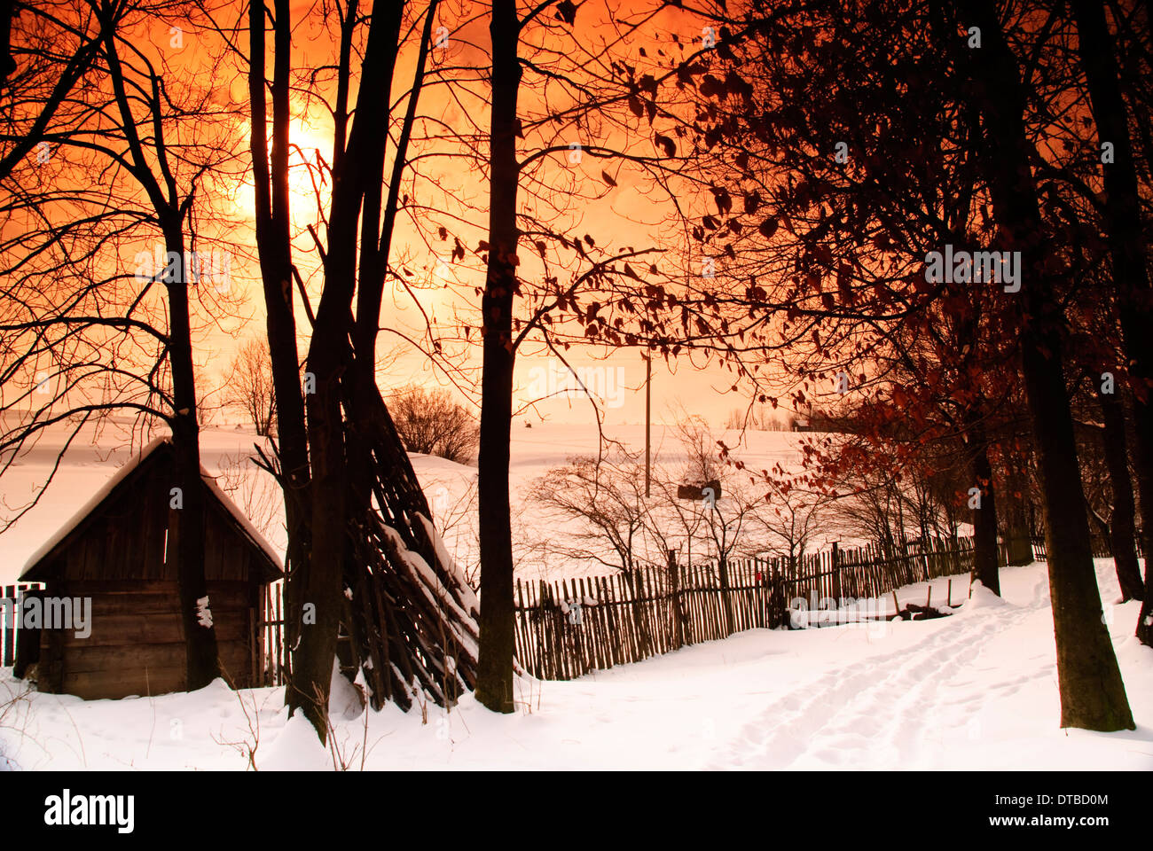Rural winter mountain landscape with sundown and road, trees, fence ...