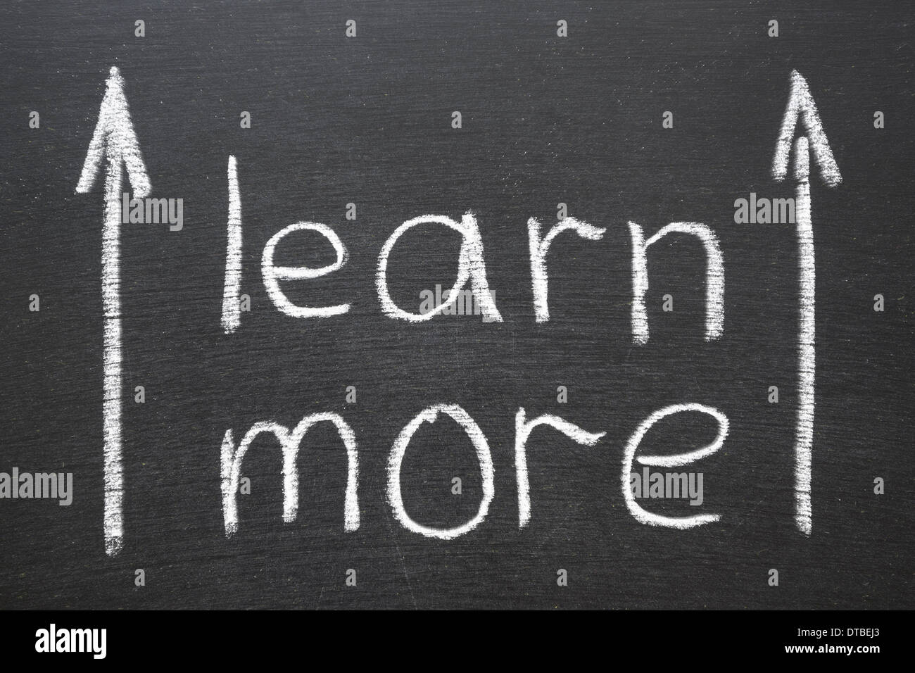 learn more phrase handwritten on school blackboard Stock Photo - Alamy